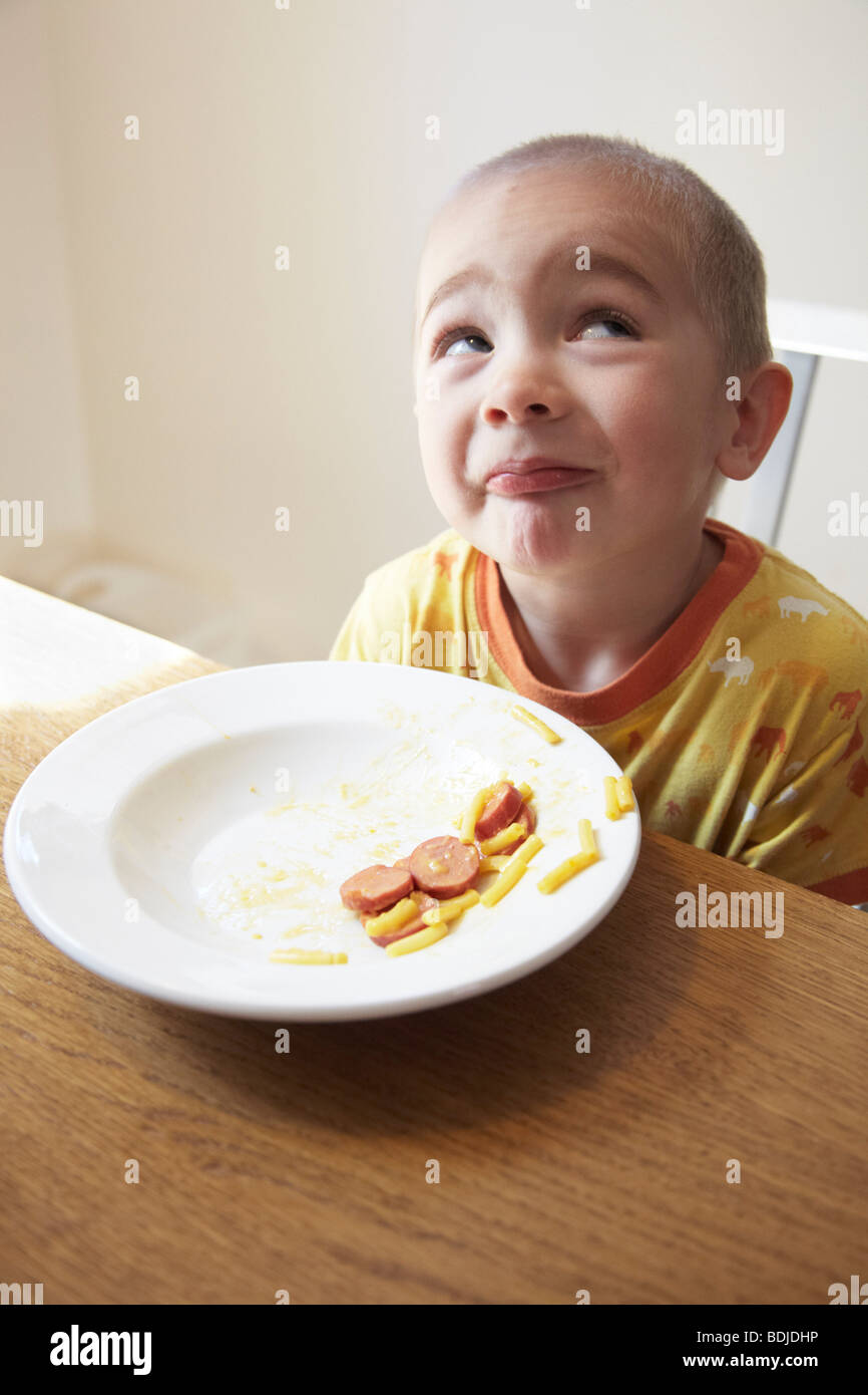 Boy Making a Funny Face while Eating at Table Stock Photo - Alamy