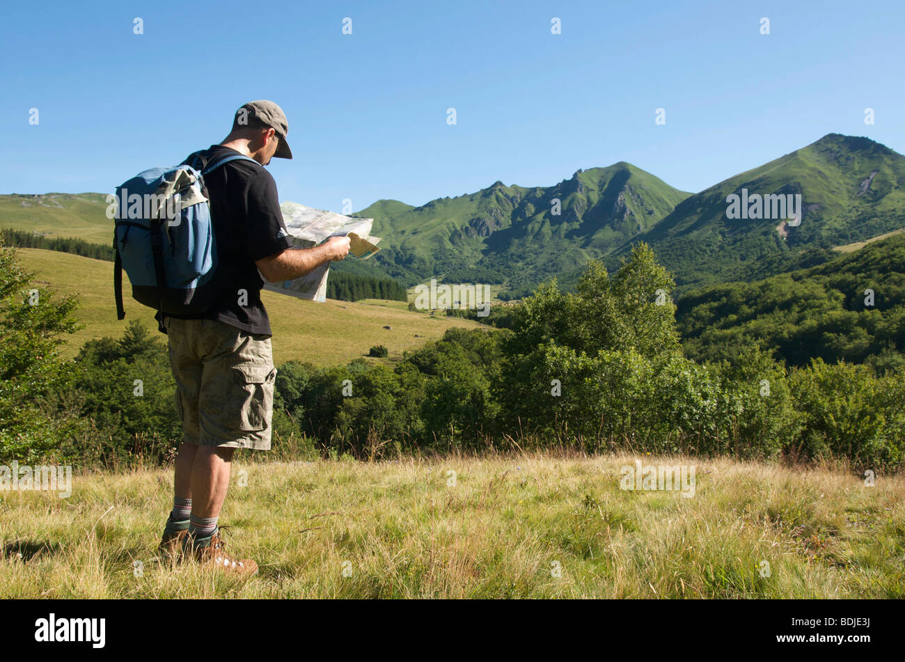 Backpacker hiker using a map while hiking in the Auvergne countryside ...