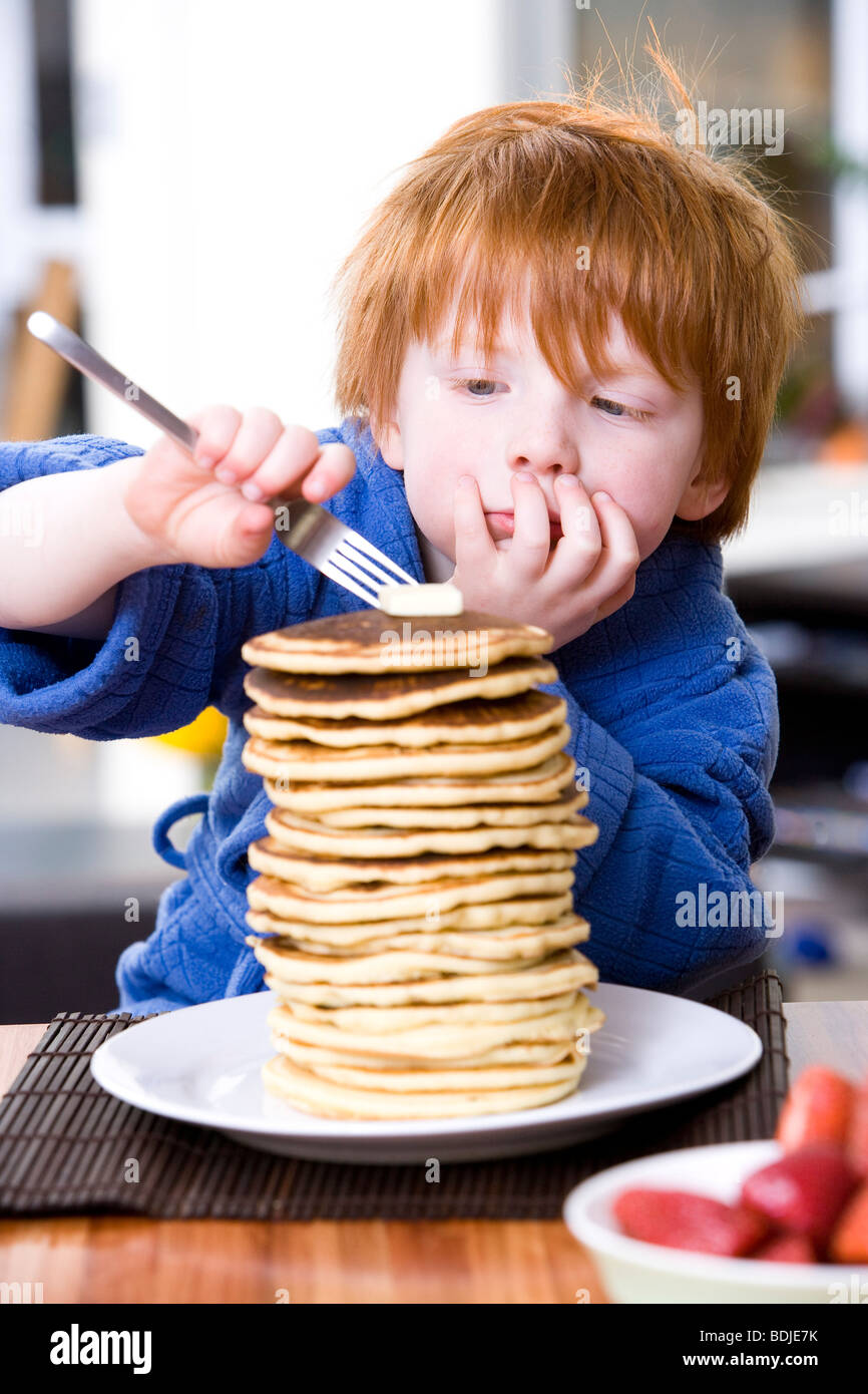 Little Boy Eating a Stack of Pancakes Stock Photo - Alamy