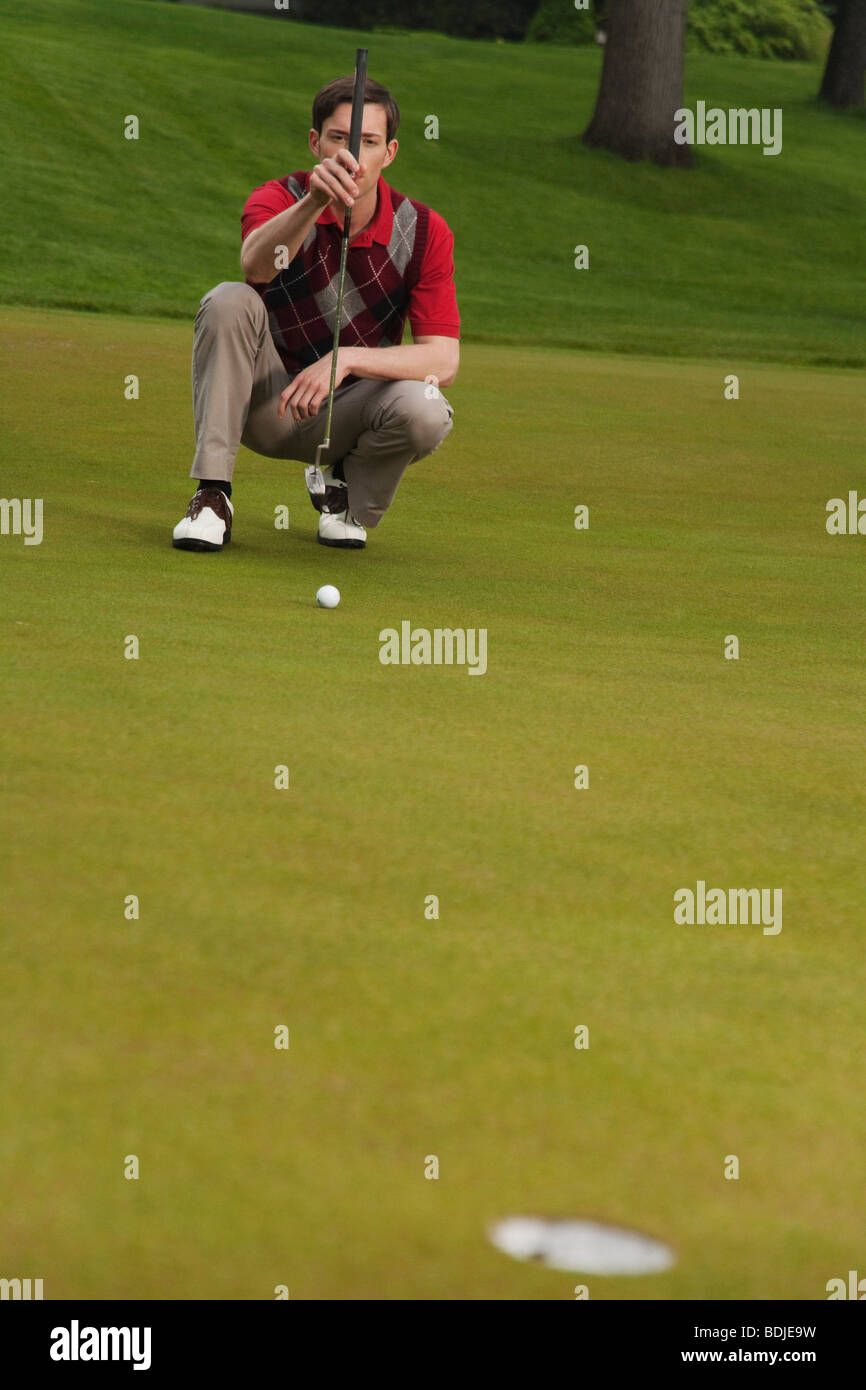 Man Assessing Golf Putt Stock Photo - Alamy