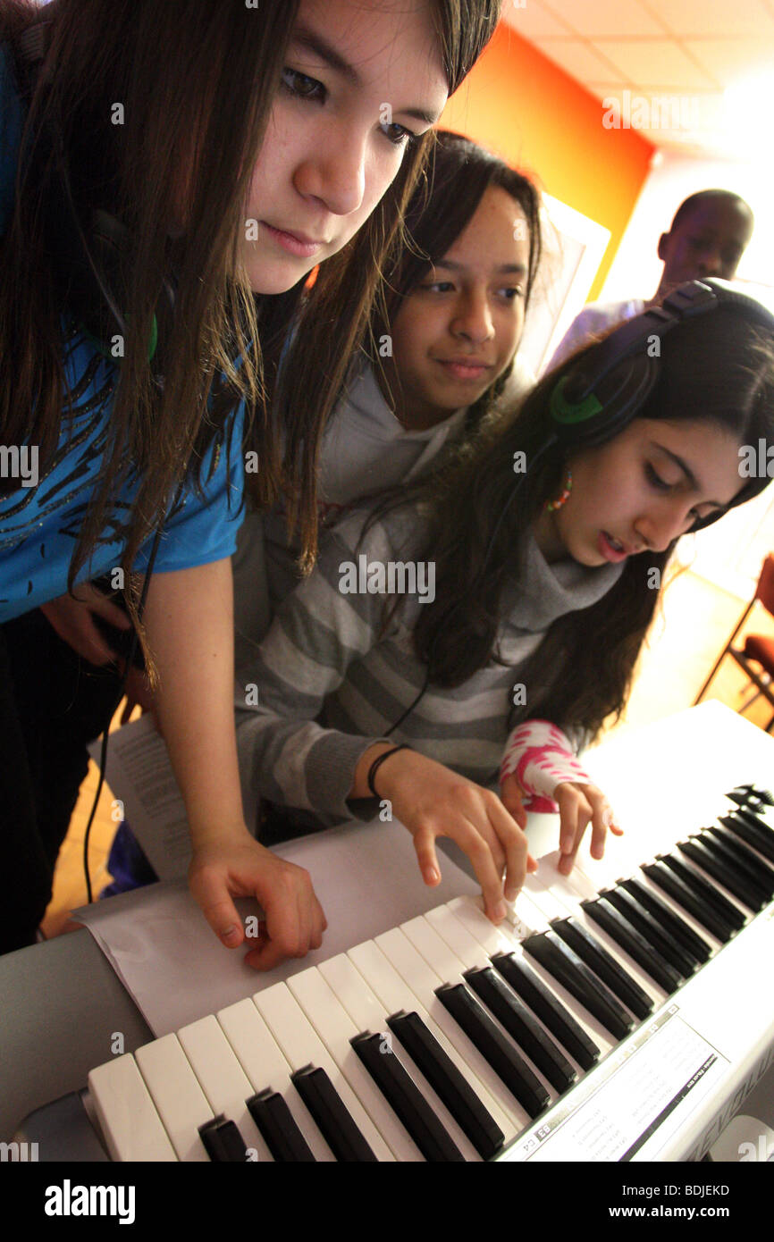 Four young people learning to play the keyboards Stock Photo - Alamy
