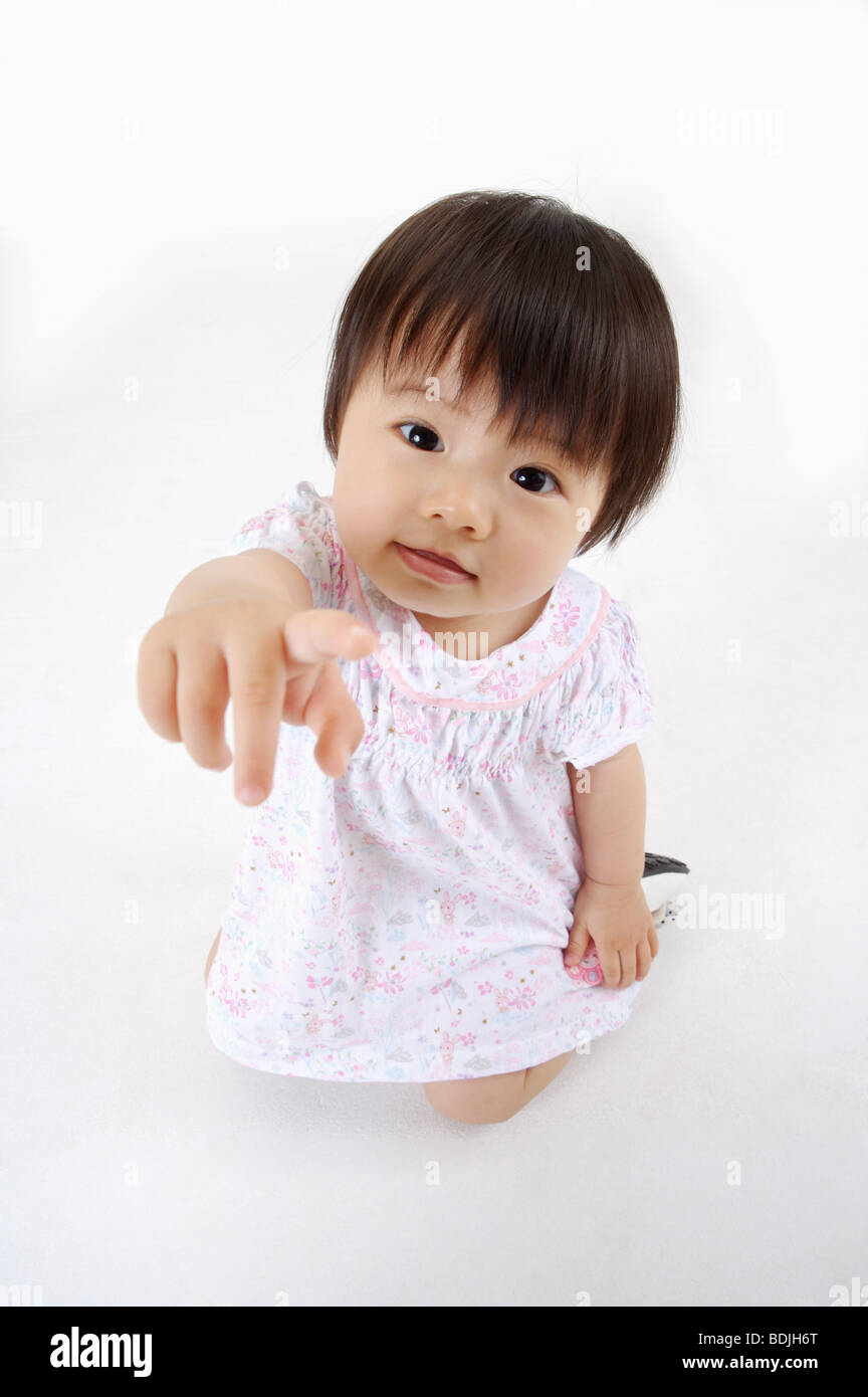 Baby girl looking at the camera and pointing,Child Stock Photo - Alamy