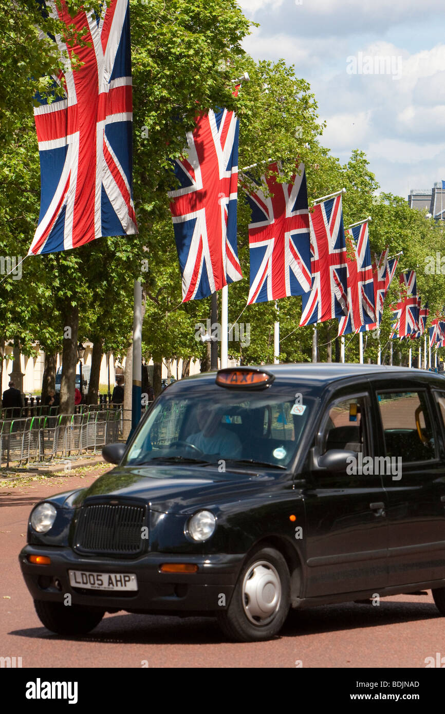 Row of Union Jack flags flying along The Mall, London as black cab ...