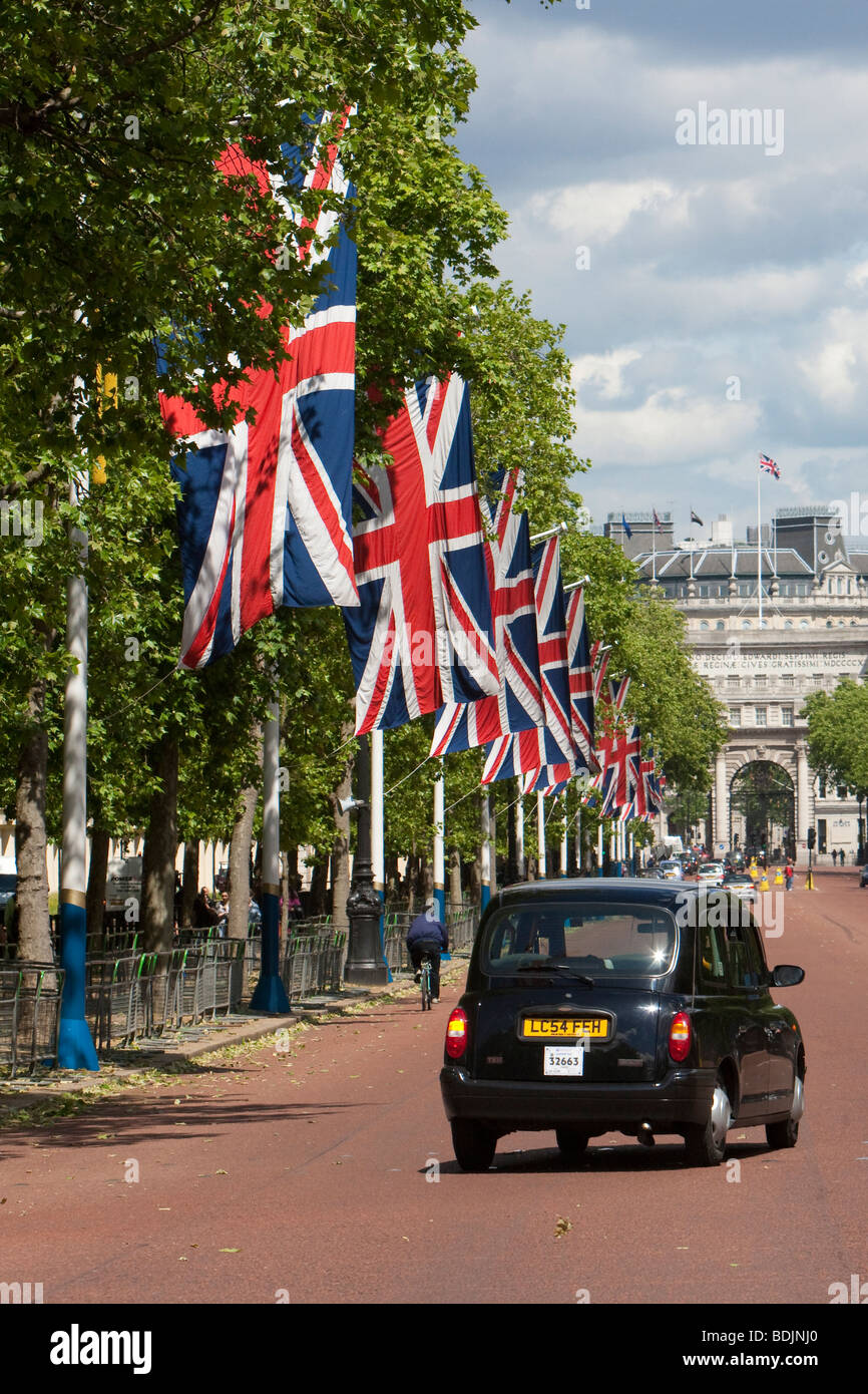 Row of Union Jack flags flying along The Mall, London as black cab ...