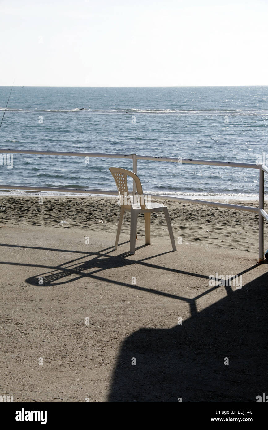one plastic chair by sea in sun Stock Photo - Alamy