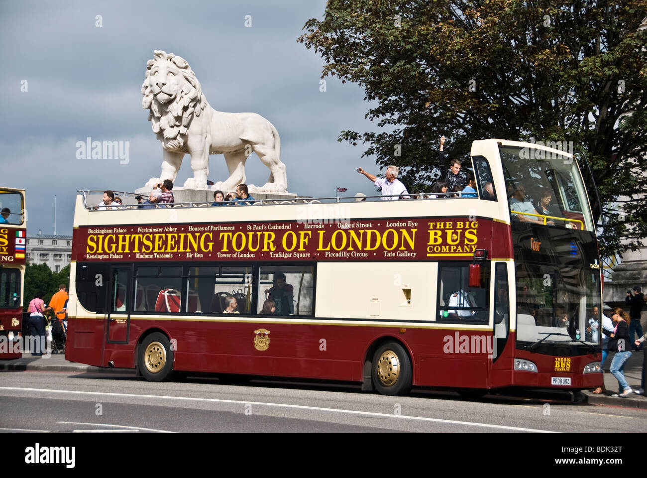 London Sight Seeing Bus with tourist taking picture of a statue of a ...