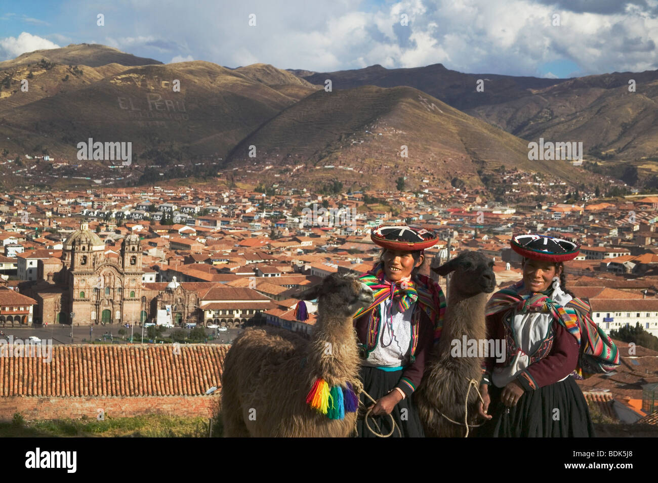Indian women with llamas, Plaza de Armas with Andes Mountains as ...