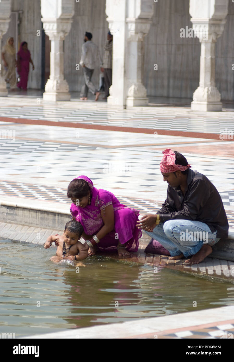a mother and father bath their child Stock Photo - Alamy