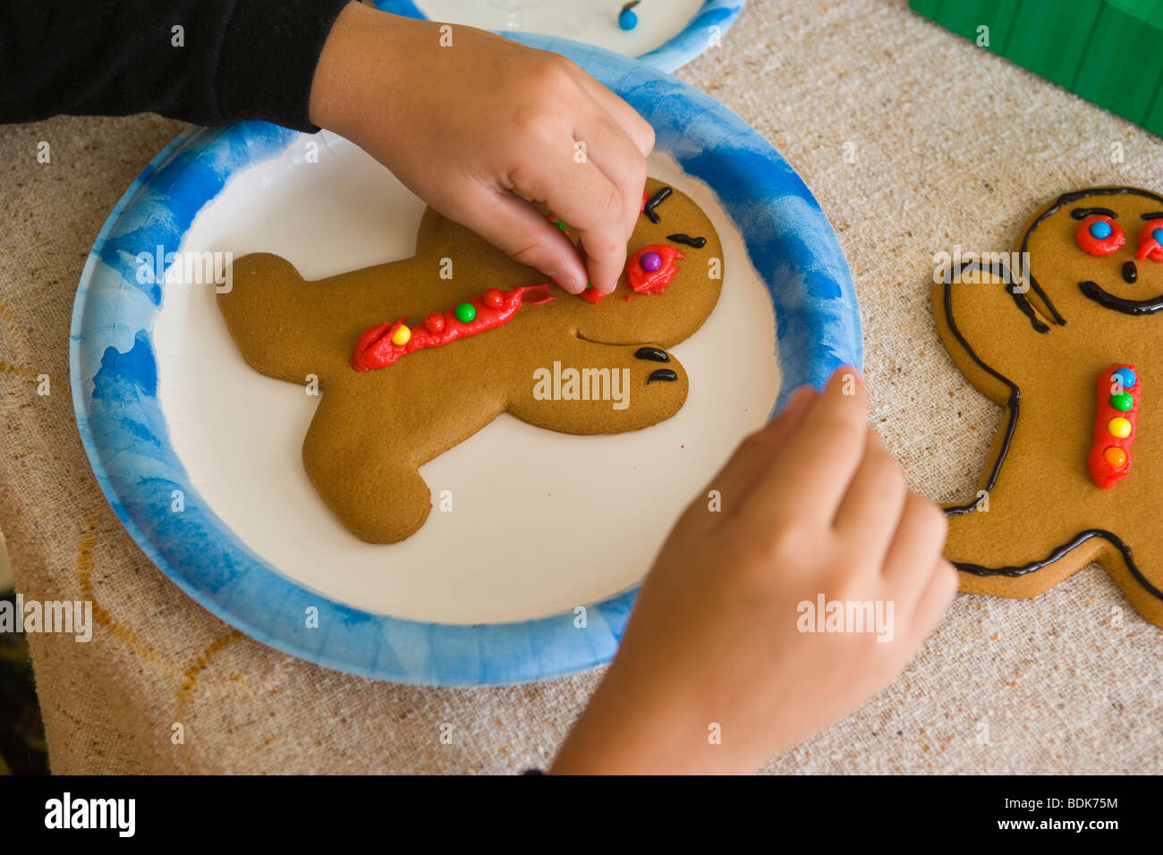 Boy icing a gingerbread man, Close up Stock Photo - Alamy