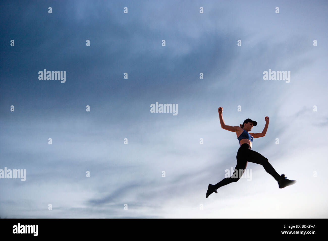 Energetic, healthy woman hiker leaping across precipice Stock Photo - Alamy