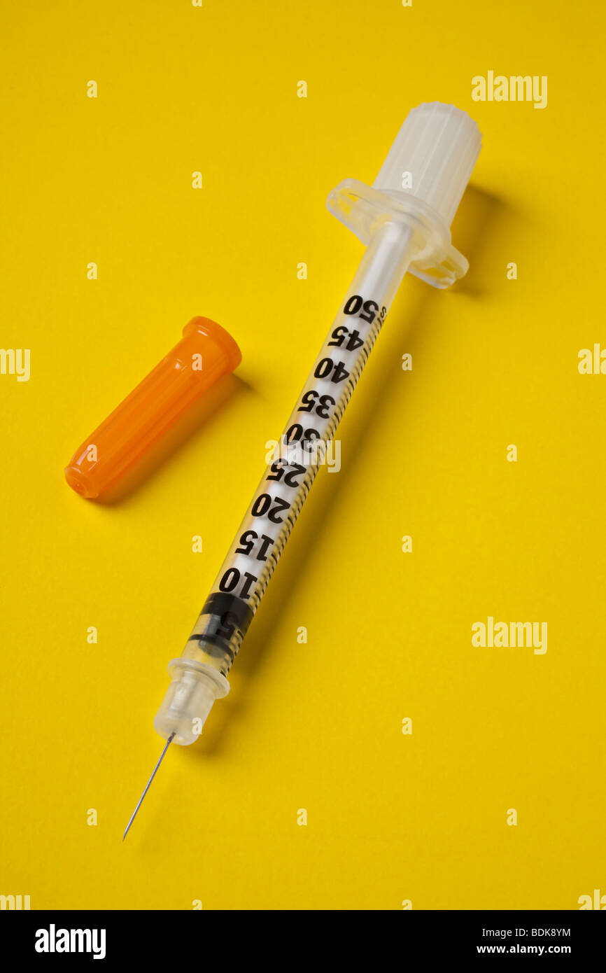 Syringe on yellow background Stock Photo - Alamy