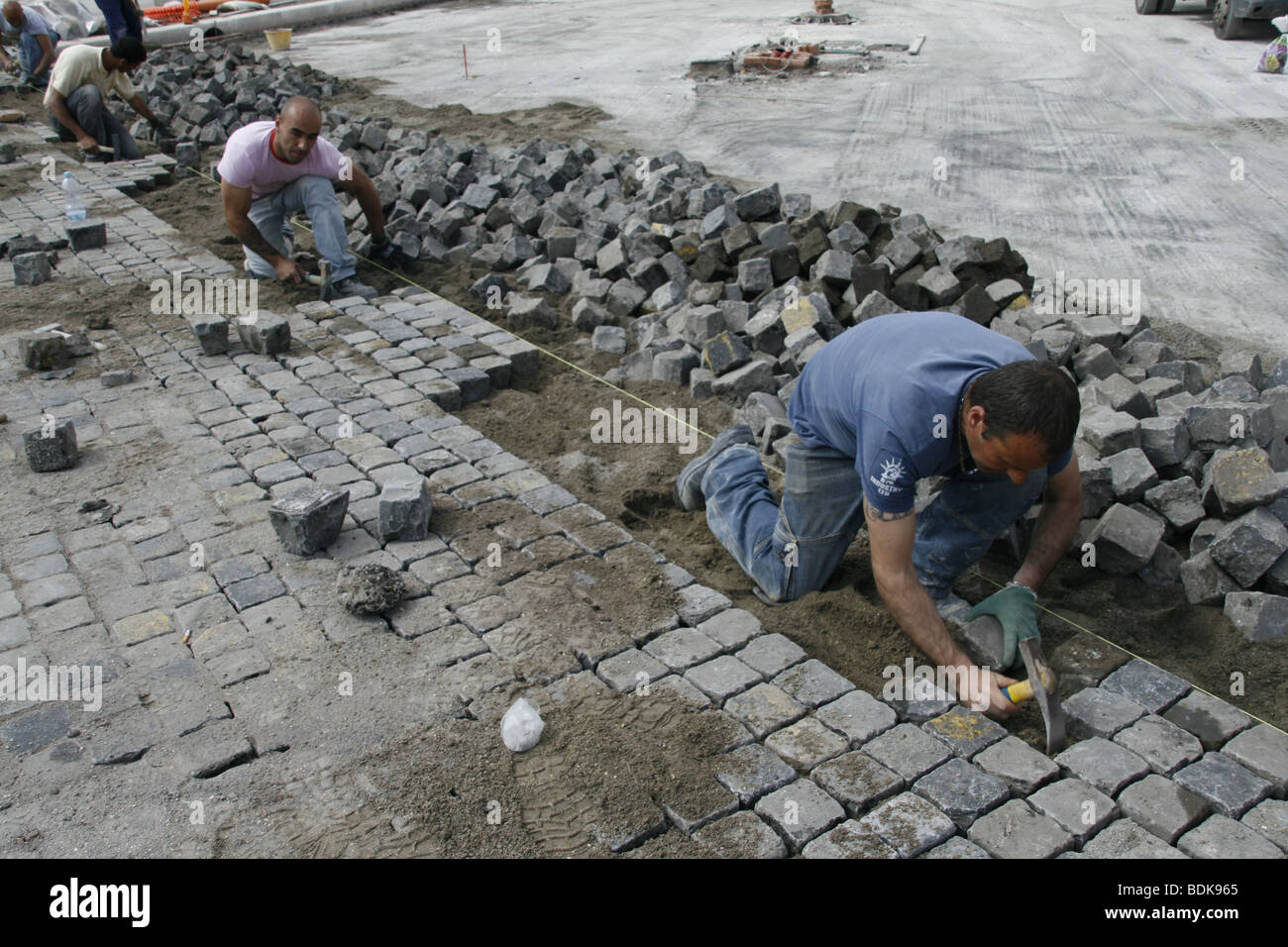 workers resurfacing cobbled street in rome, italy Stock Photo - Alamy