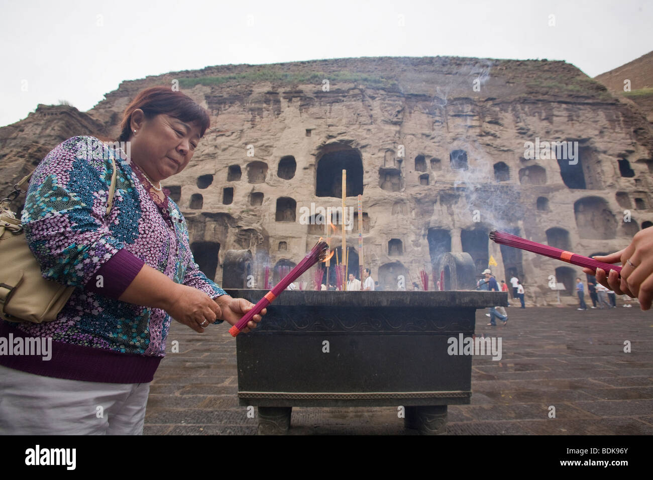 Buddhists light incense at the Yungang Shiku Buddhist Caves complex ...