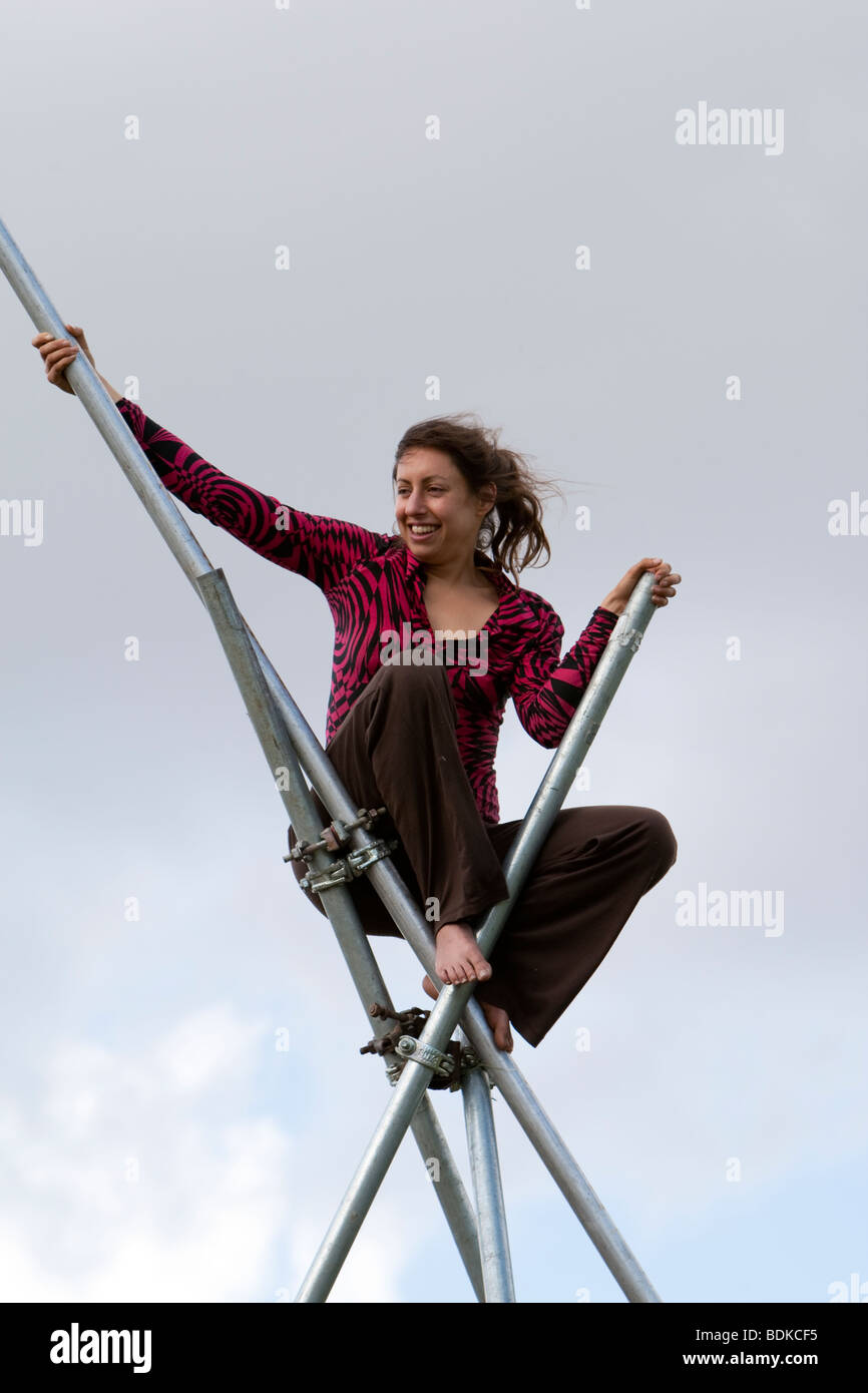 Young woman sits on scaffolding tripod at the Climate Change Camp ...