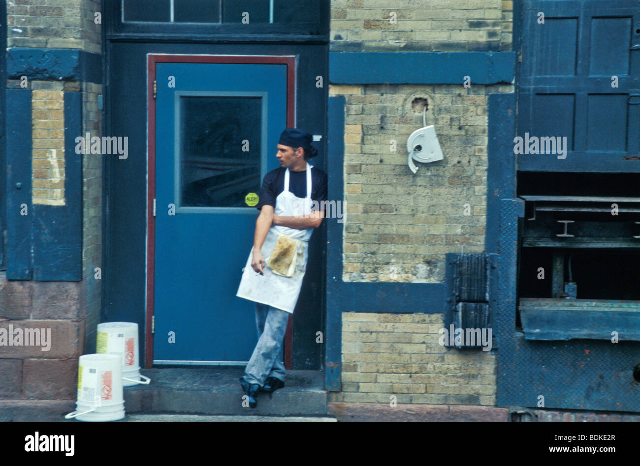 Restaurant kitchen worker on smoke break outside building Stock Photo ...