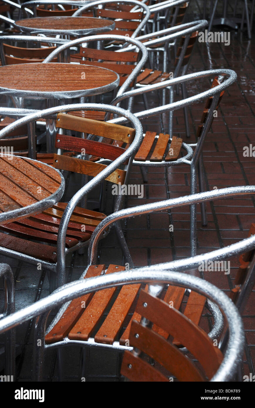 Rain and wooden tables with chairs in town Stock Photo - Alamy