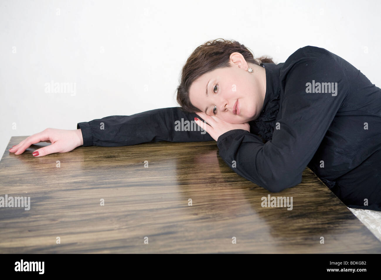 Upset woman lying on table Stock Photo - Alamy