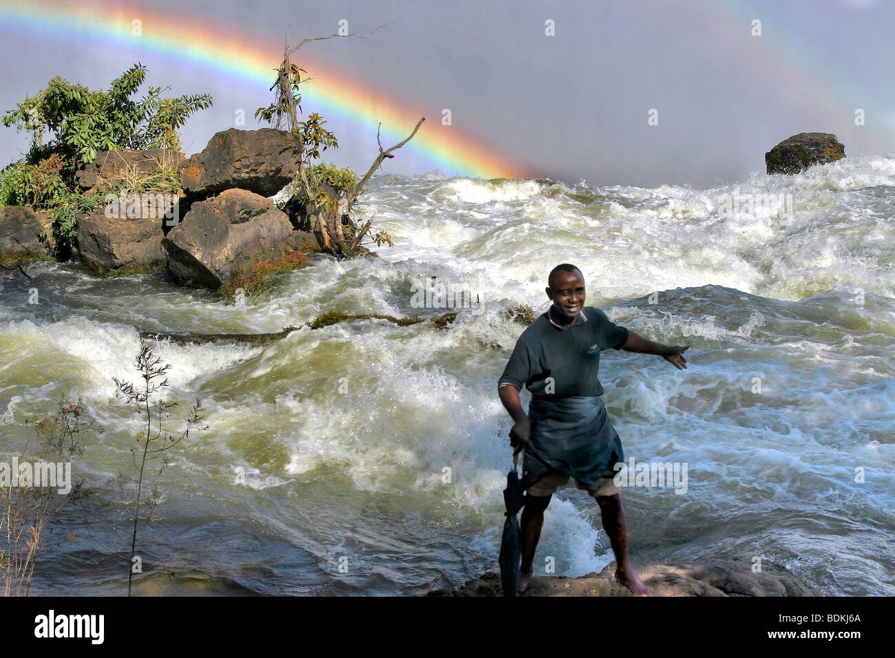 Tourist strolls along the slippery rocks of the Victoria Falls head ...