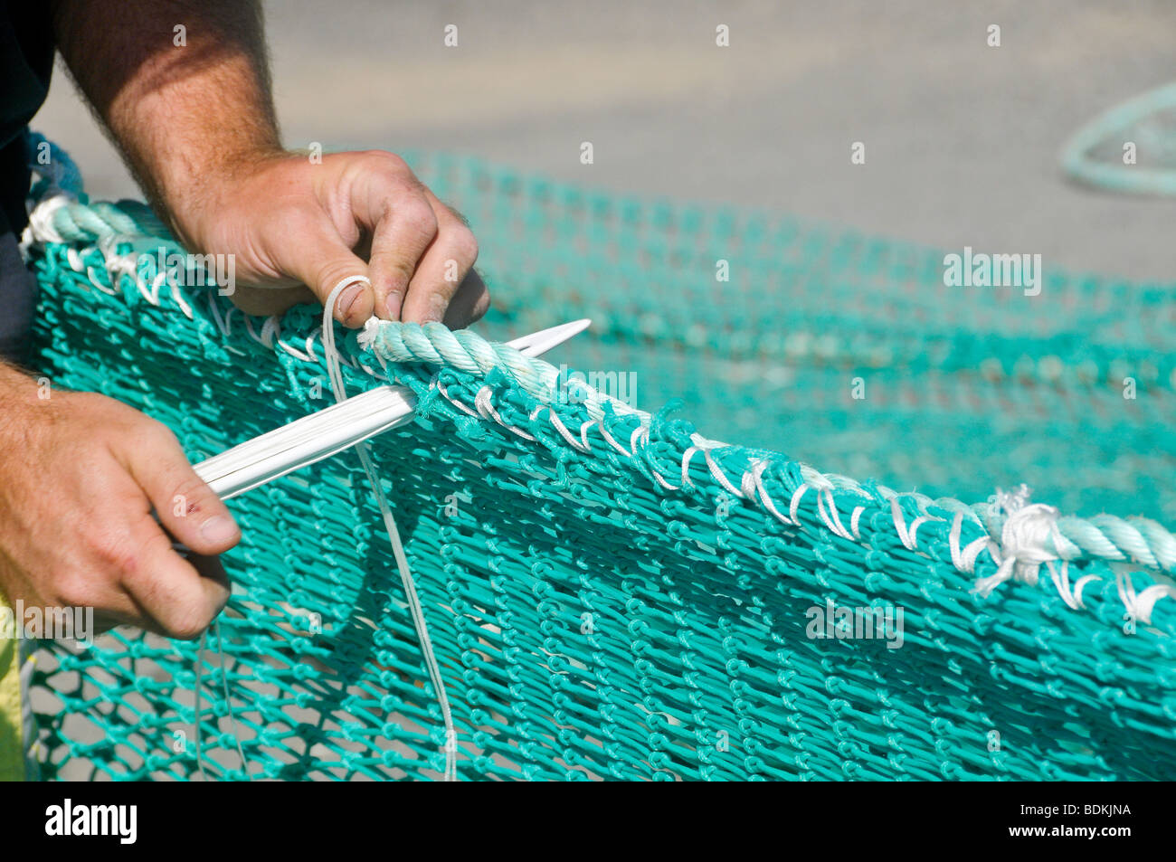 Fisherman mending his net Stock Photo - Alamy