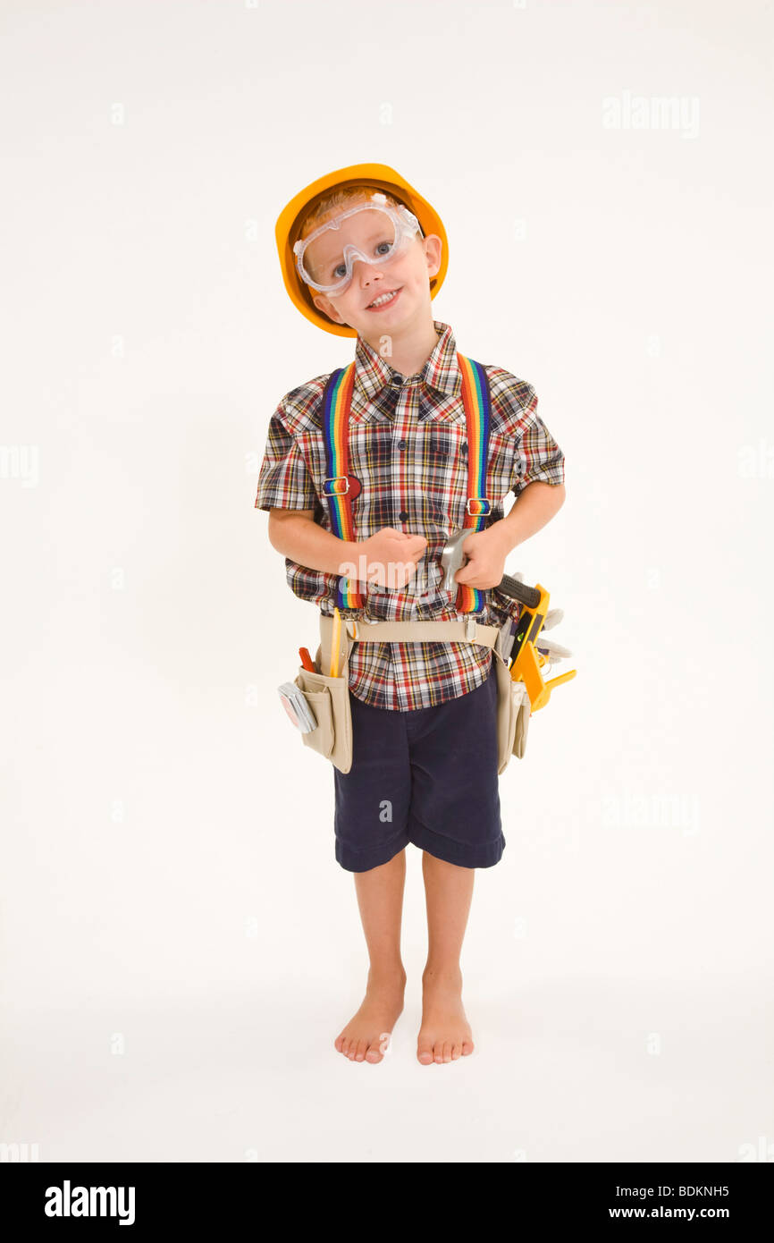 Young caucasian boy dressed in a carpenter outfit standing on a white ...