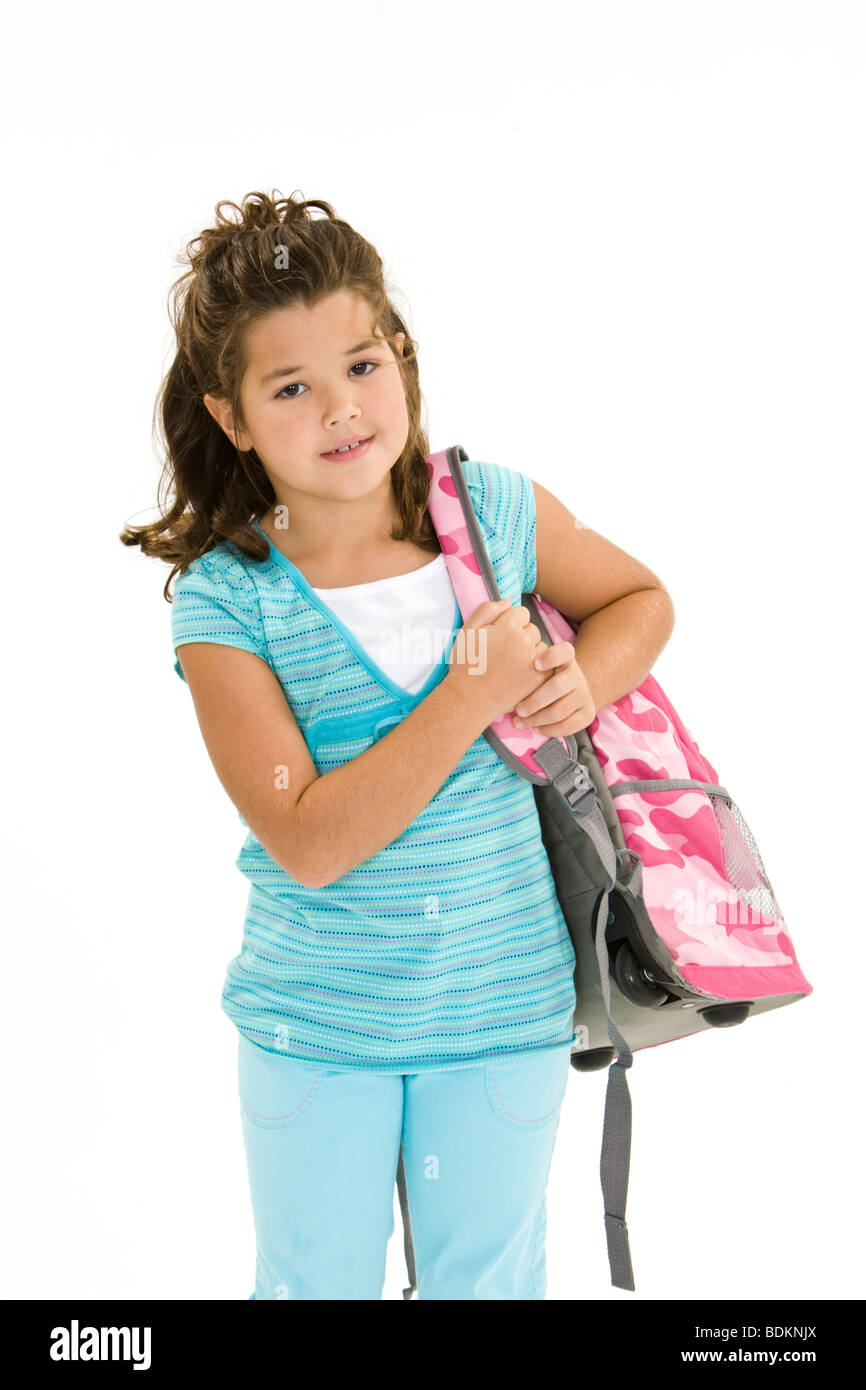 Child holding a school backpack and standing on a white background ...