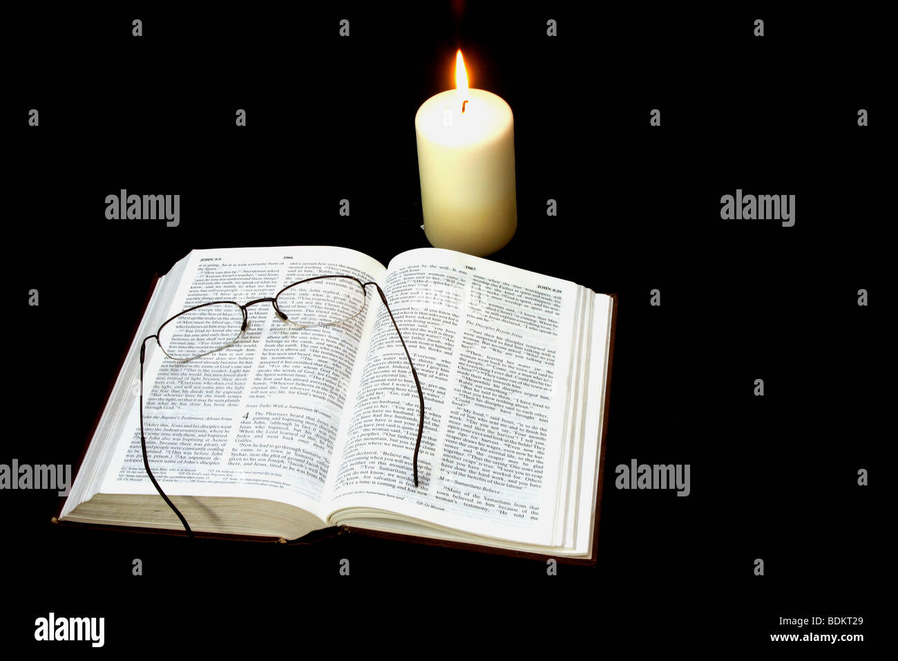 Late night bible study by candle light, isolated on black Stock Photo ...