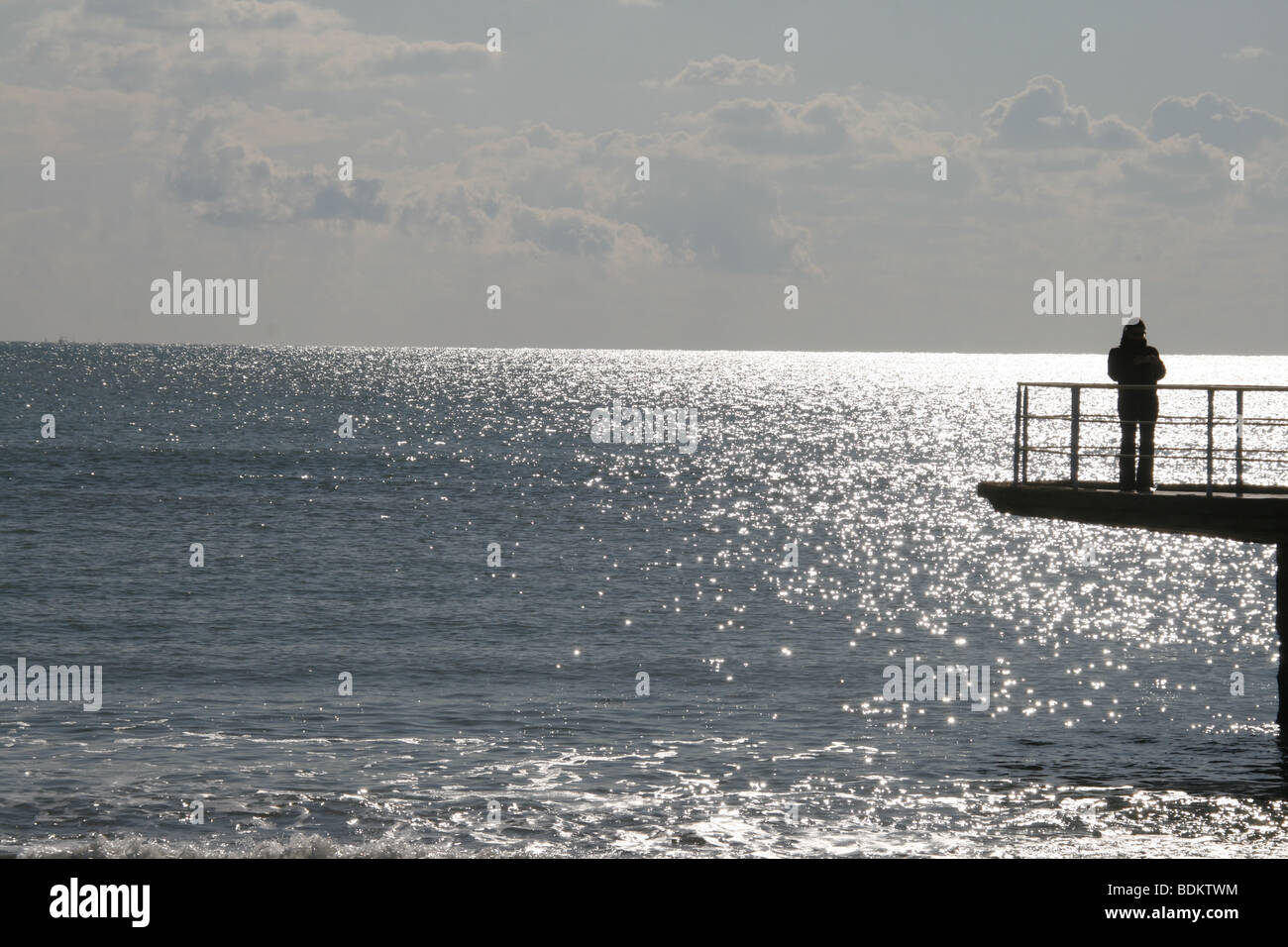 one person relaxing on pier by sea Stock Photo - Alamy