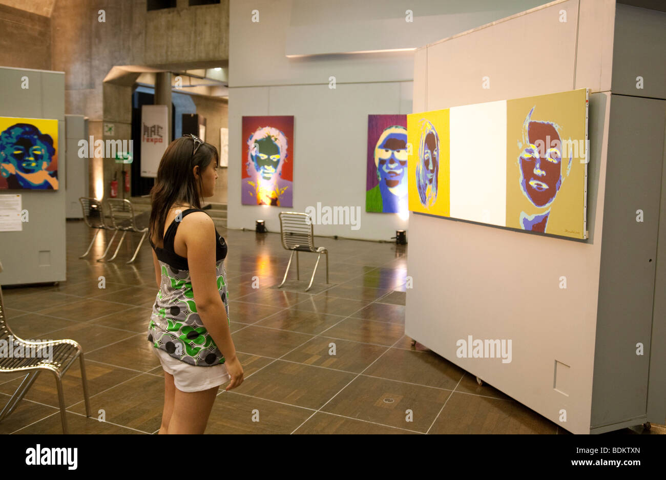 A teenager looking at portraits by the artist Dimitri, in the art ...