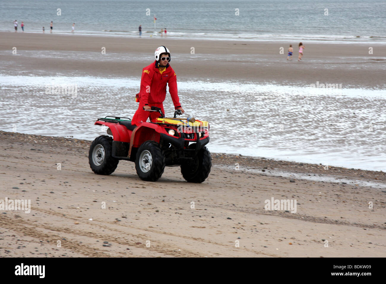 RNLI Lifeguard patrolling beach on quad bike, Mablethorpe, Lincolnshire ...