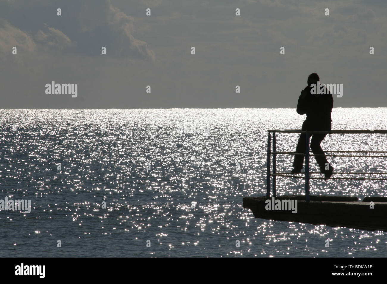 one person relaxing on pier by sea Stock Photo - Alamy