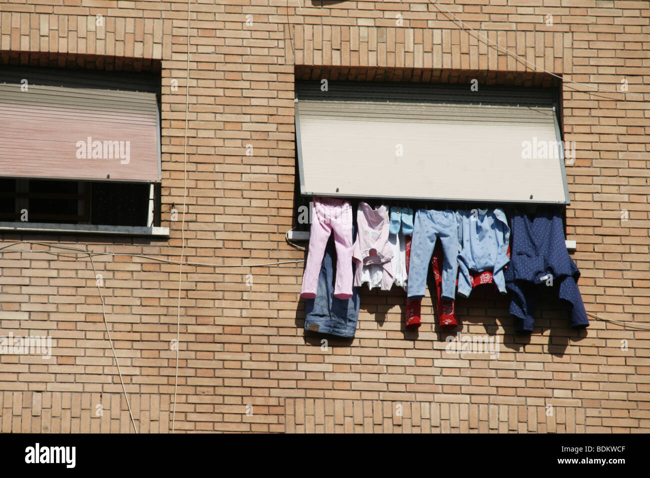 clothes on washing line by window in block of flats in italy Stock ...
