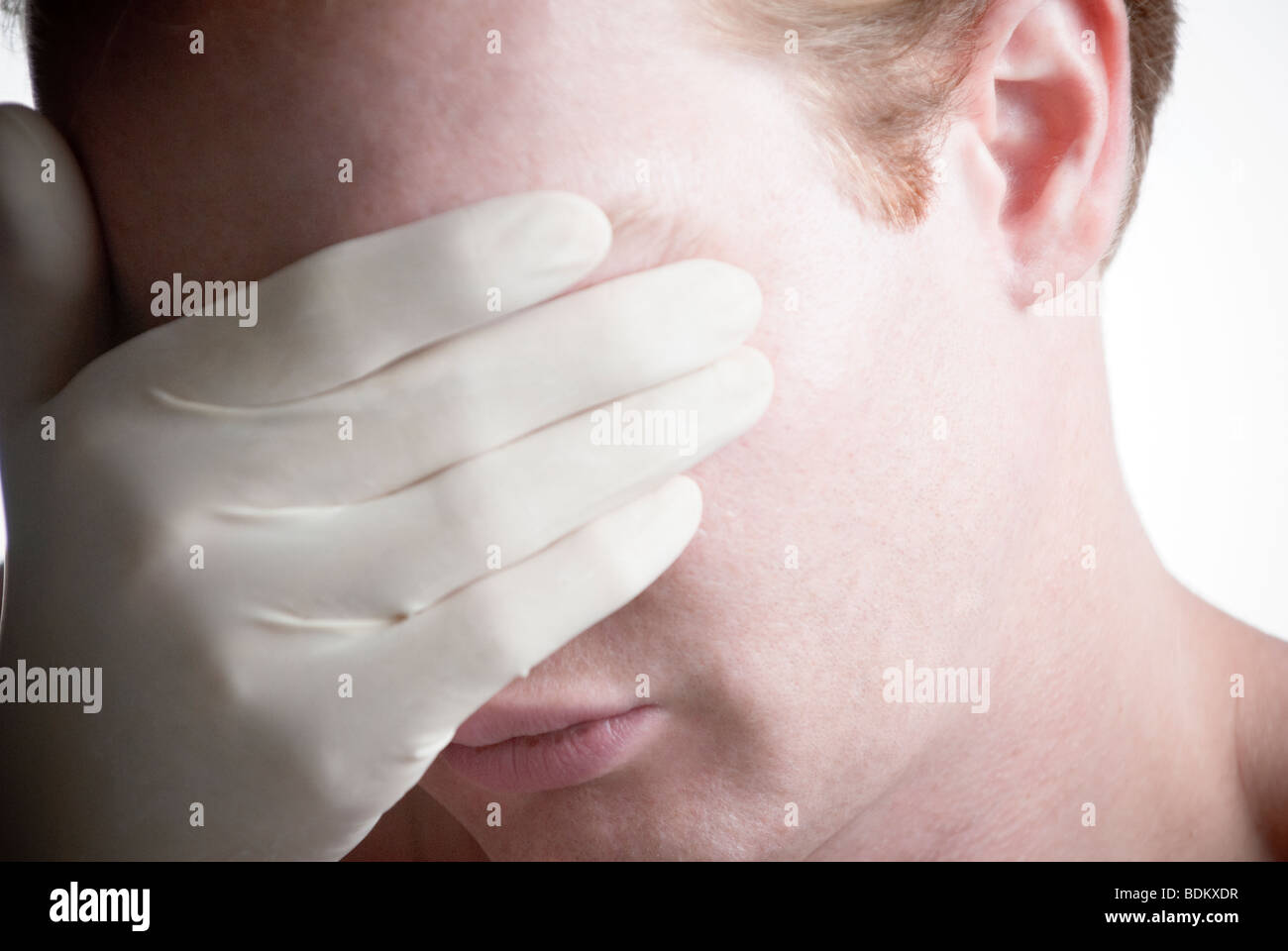 Man covering his eyes while wearing a white medical glove Stock Photo ...