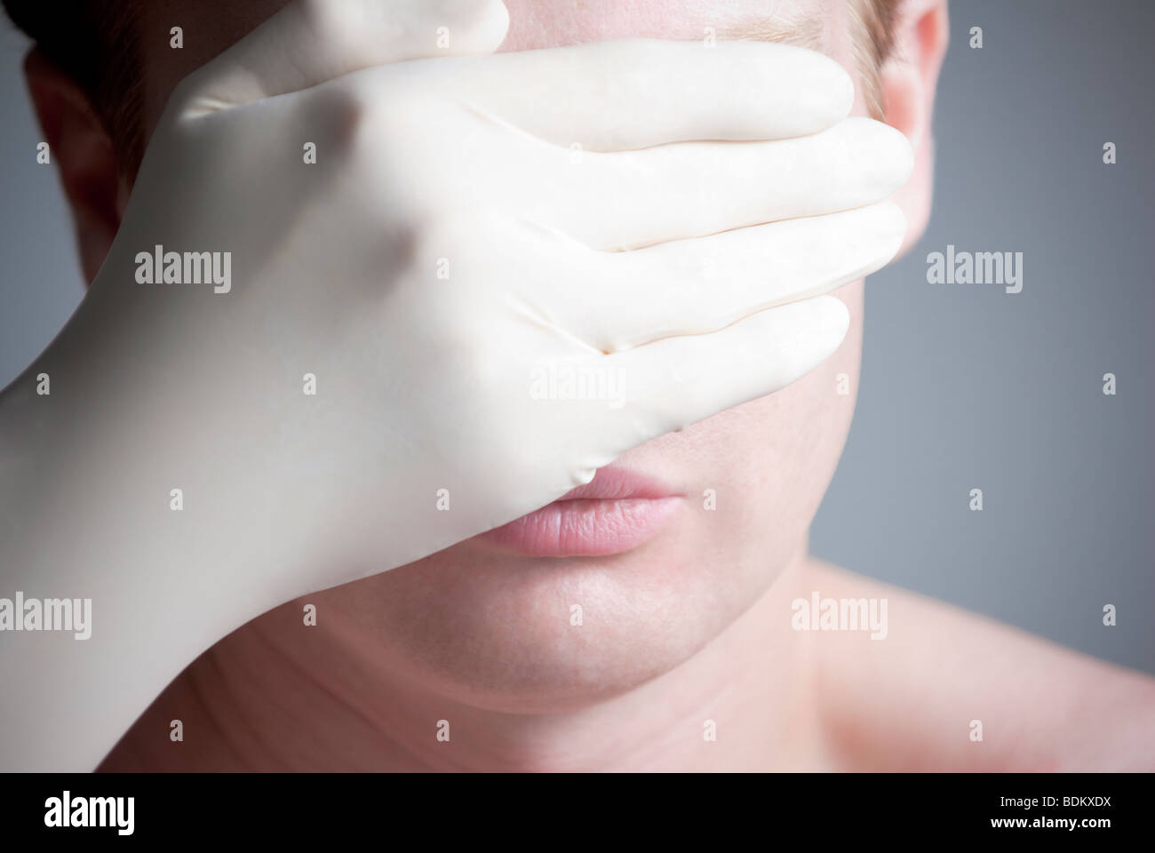 Man covering his eyes while wearing a white medical glove Stock Photo ...
