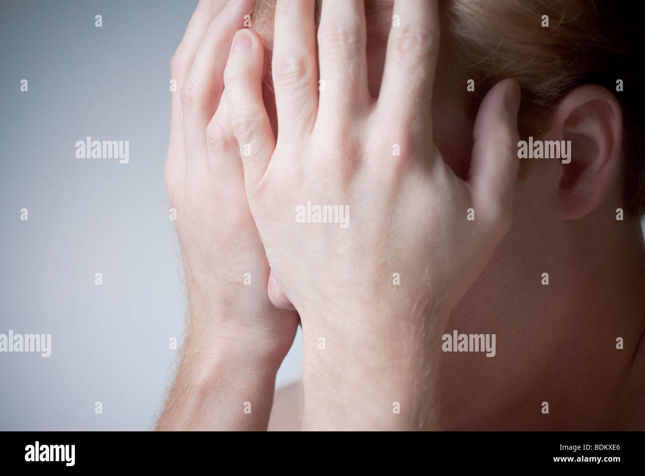 Man holding his head in his hands Stock Photo - Alamy