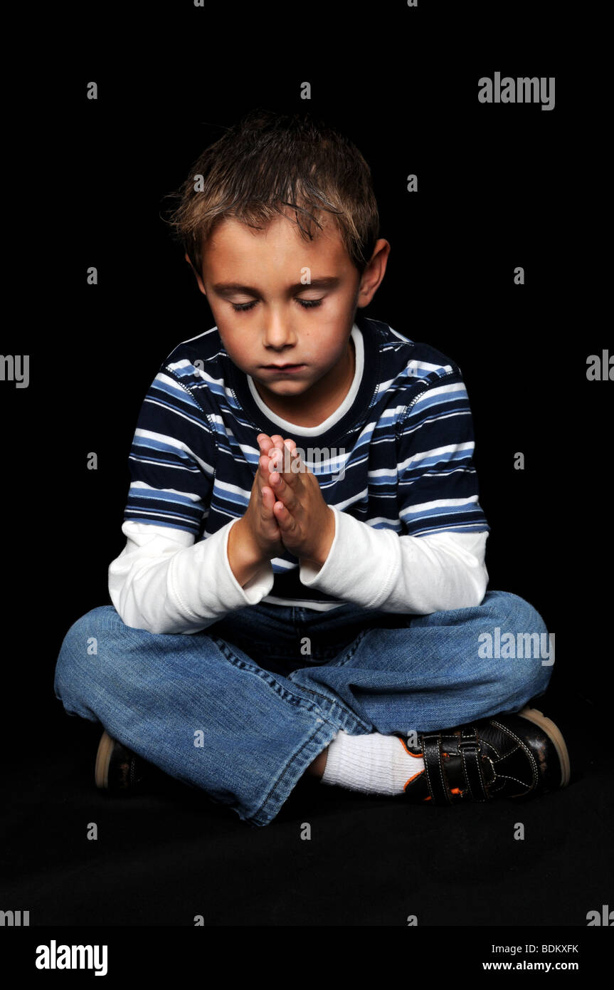 Young boy with hands together praying Stock Photo - Alamy