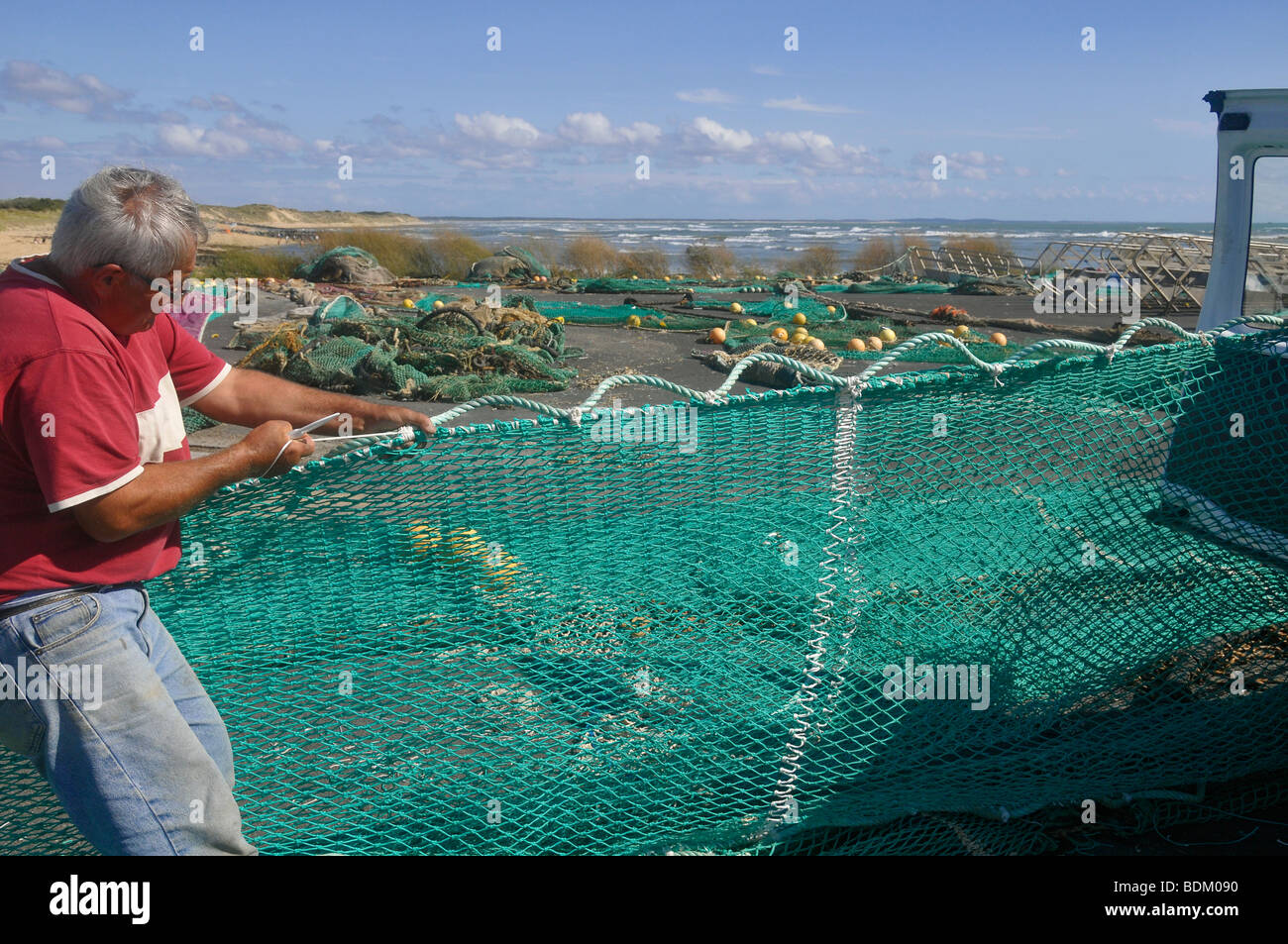 Fisherman mending his net Stock Photo - Alamy