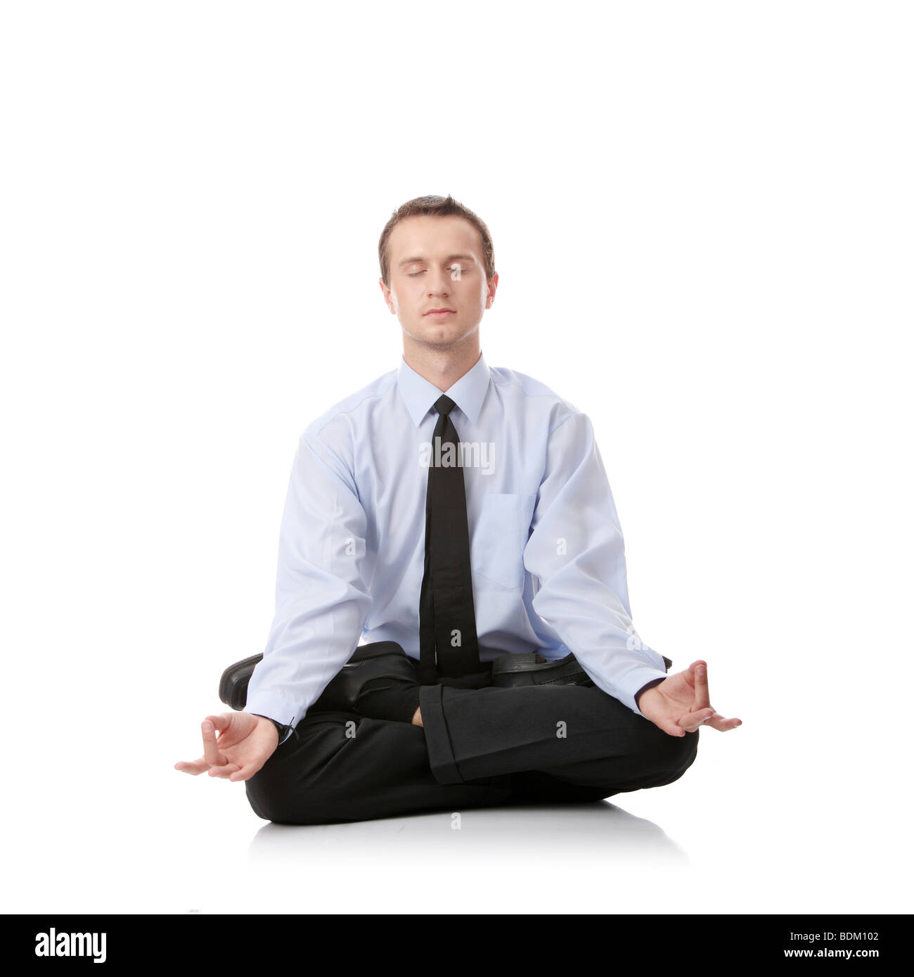 Businessman sitting in lotus position, Isolated against white ...