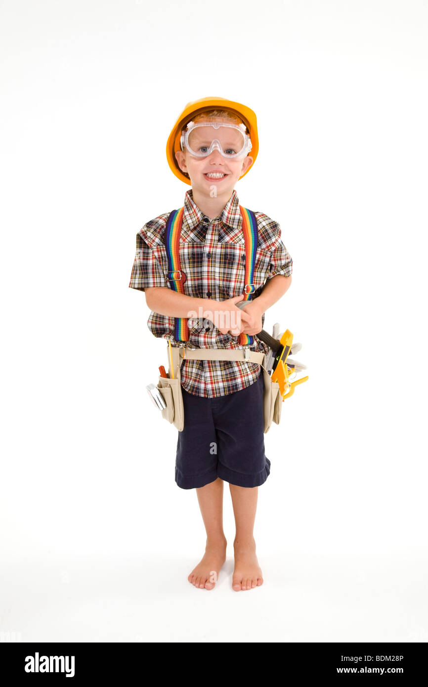Young caucasian boy dressed in a carpenter outfit standing on a white ...