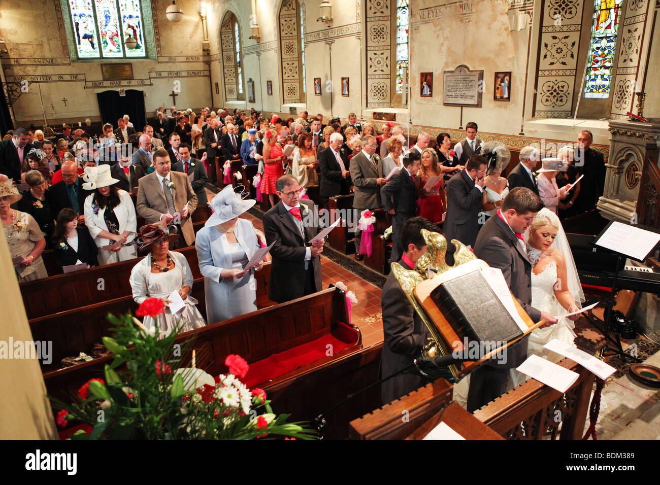 Traditional UK church wedding ceremony bride and groom at altar ...