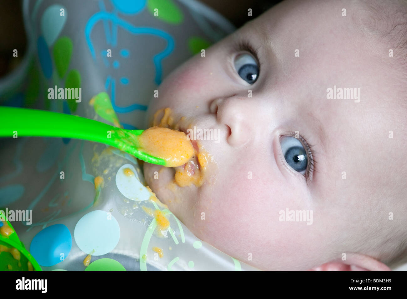 A toddler lying down eating food at meal time Stock Photo - Alamy