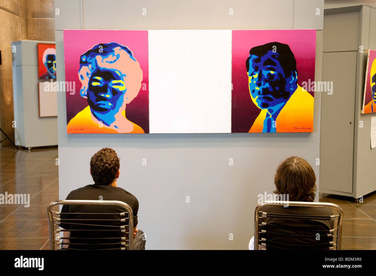 People looking at portraits by the artist Dimitri, in the art gallery ...