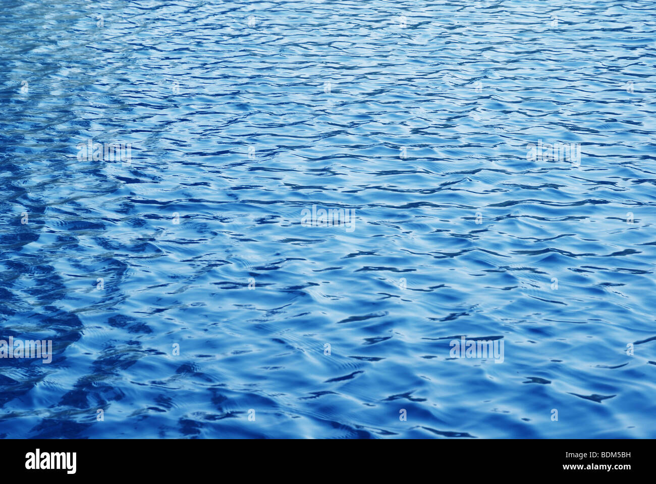 Blue shiny water with ripple. Reflection of spring sky in glassy ...