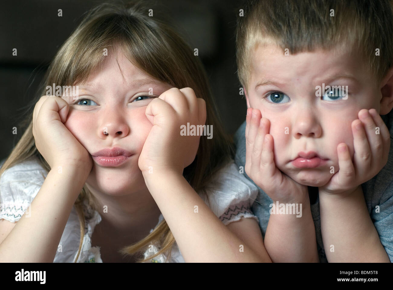 Depressed looking Brother and Sister watching television,children, chin ...