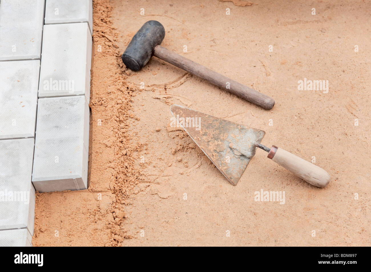 Tools of the mason on a sand surface - trowel and hammer Stock Photo ...