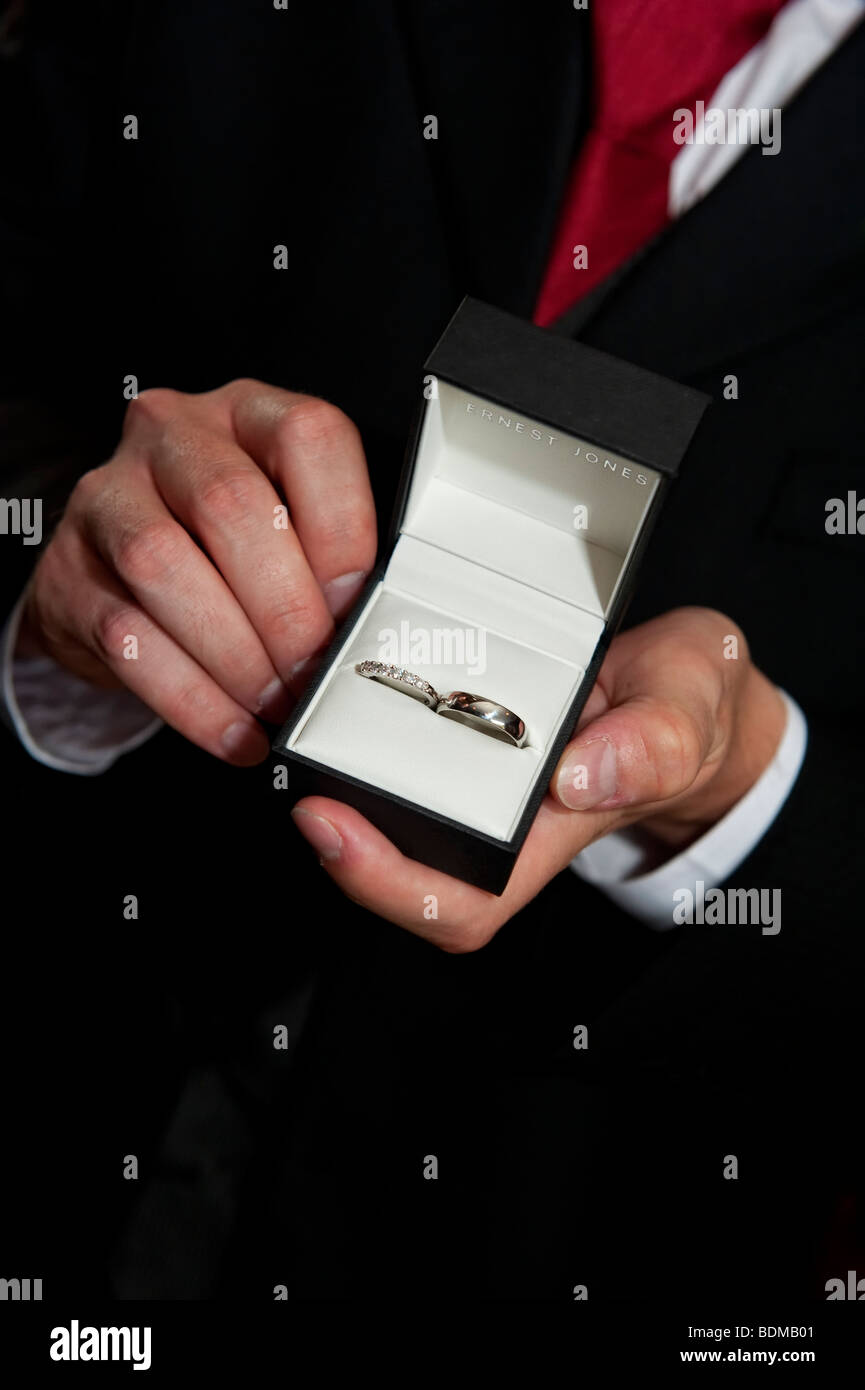 Man holding two wedding rings in a box Stock Photo - Alamy