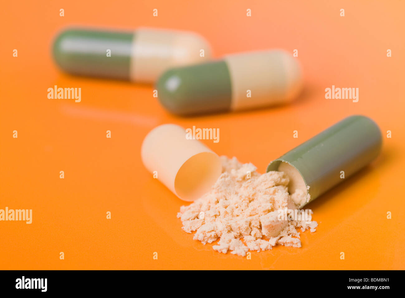 the color capsules on orange background Stock Photo - Alamy