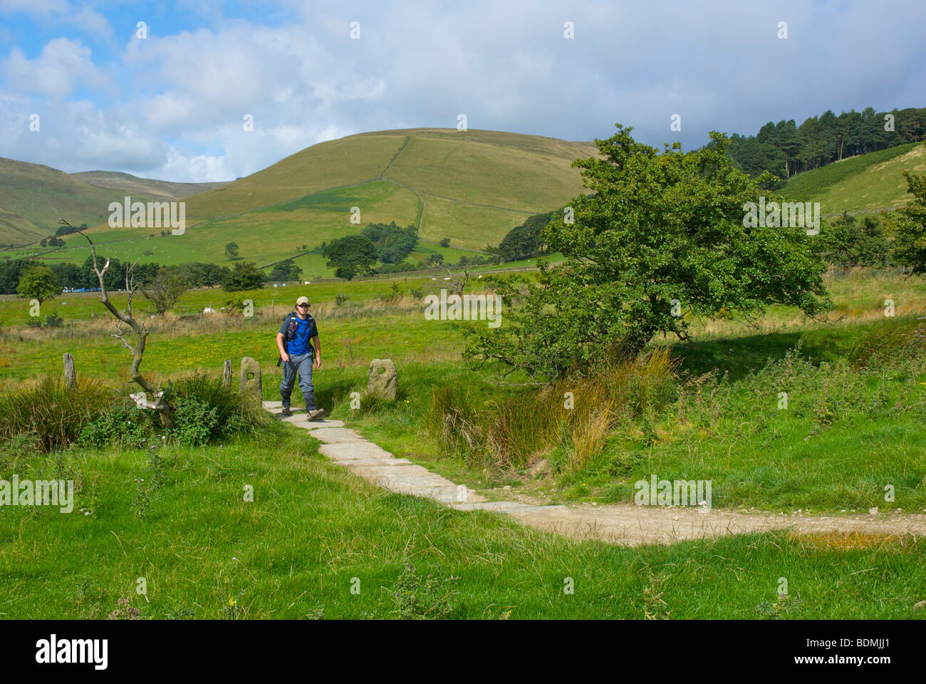 Walker on paved Pennine Way path near Upper Booth, Edale valley, Peak ...