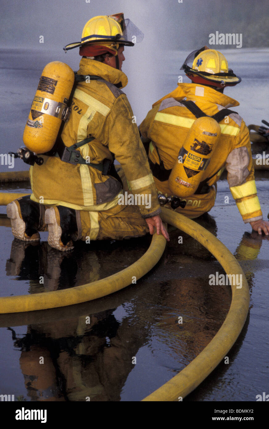 Firemen Spraying Water with Hoses Stock Photo - Alamy
