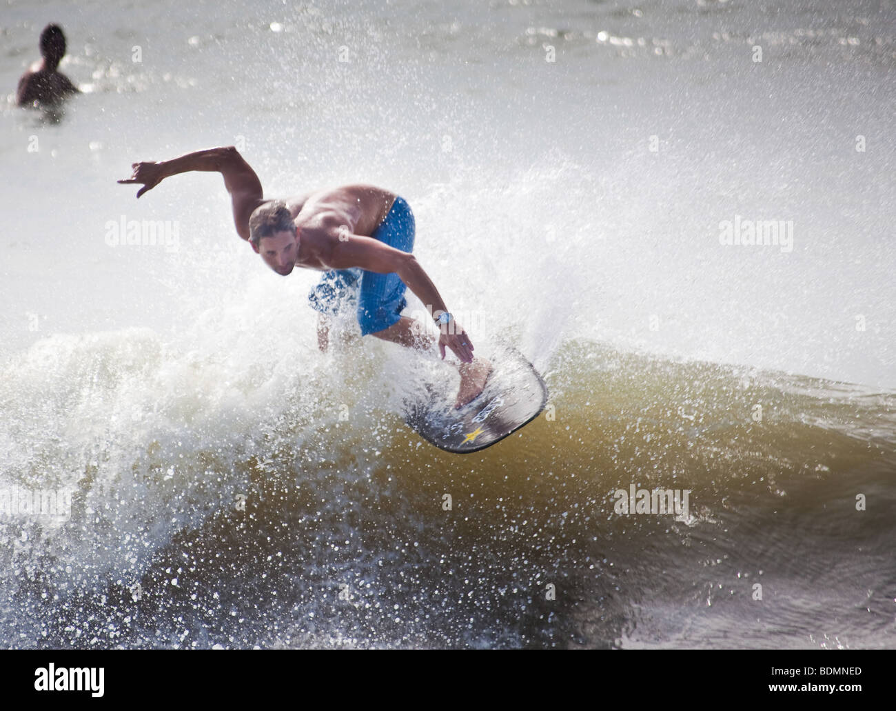 A surfer takes advantage of the ocean swell generated by a passing ...