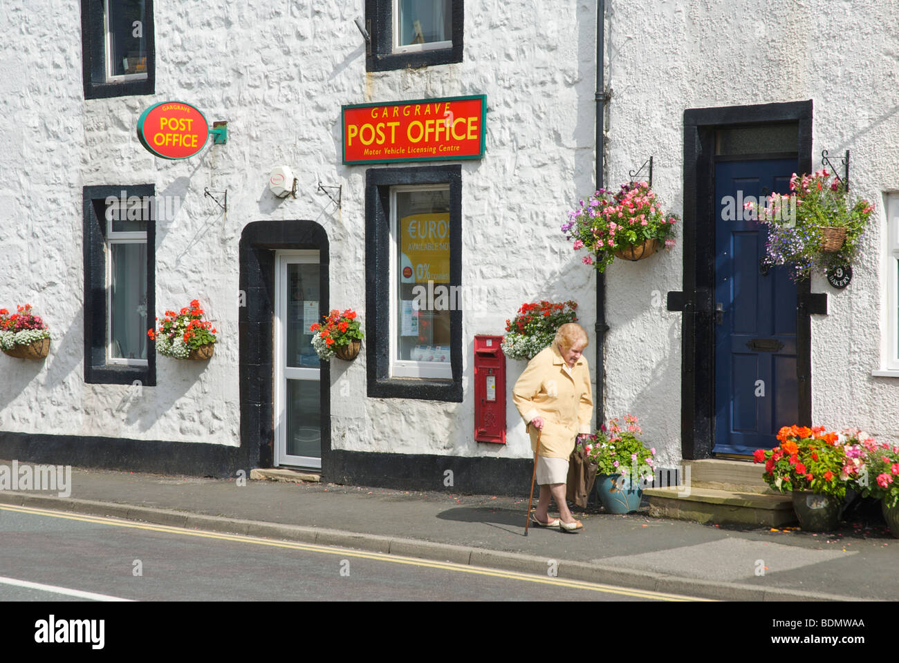 Old lady walking past Gargrave Post Office, North Yorkshire, England ...
